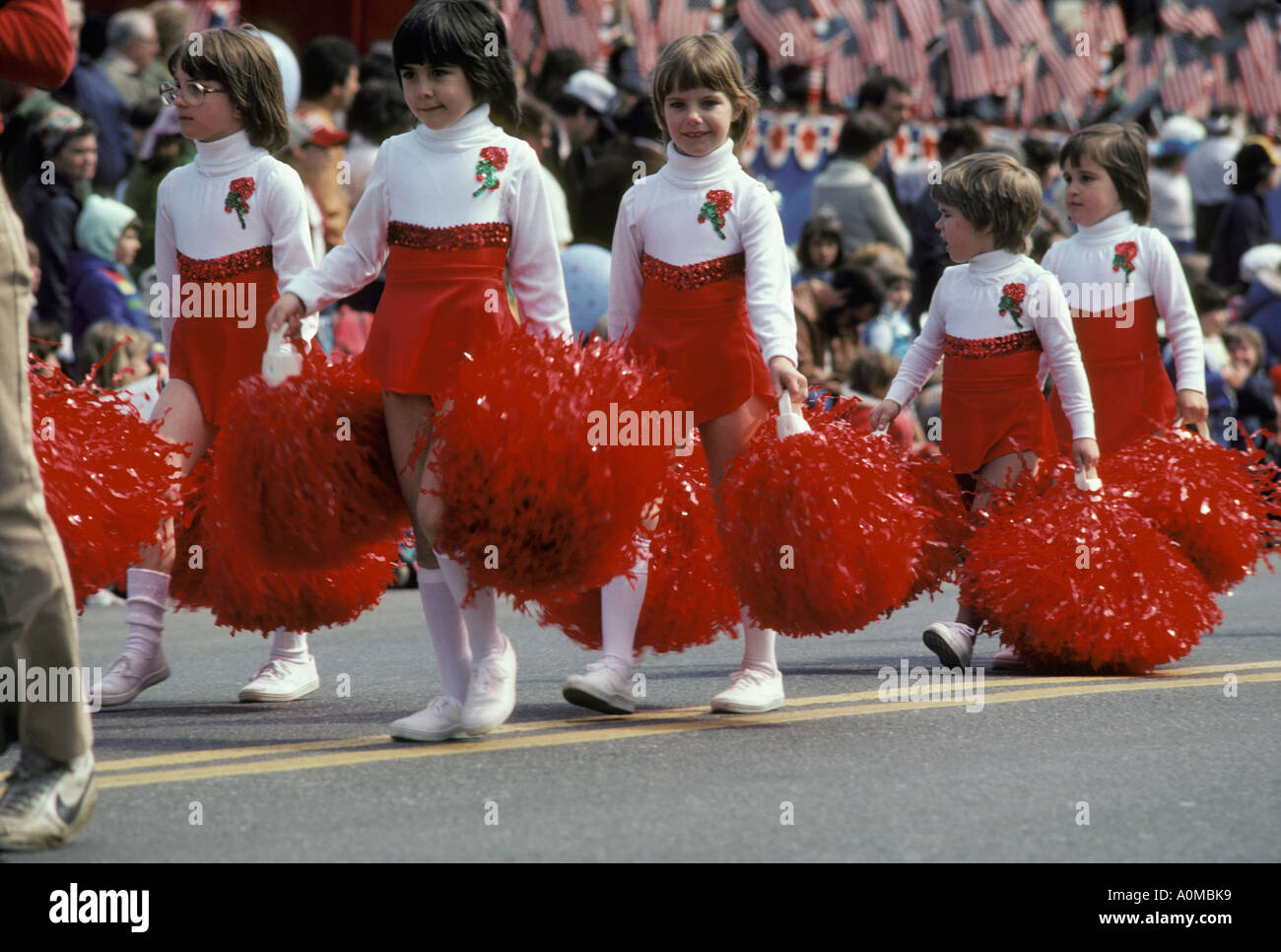 young pom pom girls community small town parade movement motion blur ...