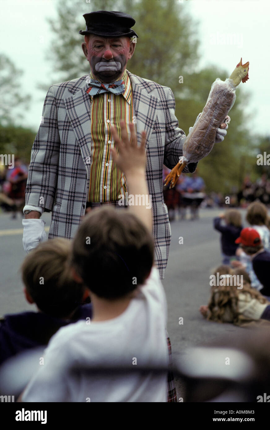 tramp clown w rubber chicken young boy parade Stock Photo - Alamy
