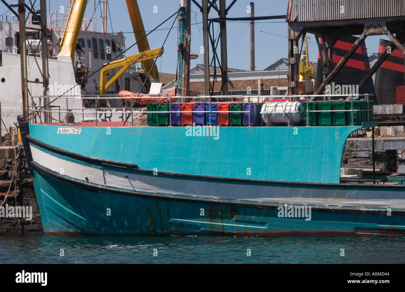 Side view of a hull of an aquamarine colored ship with several colorful ...