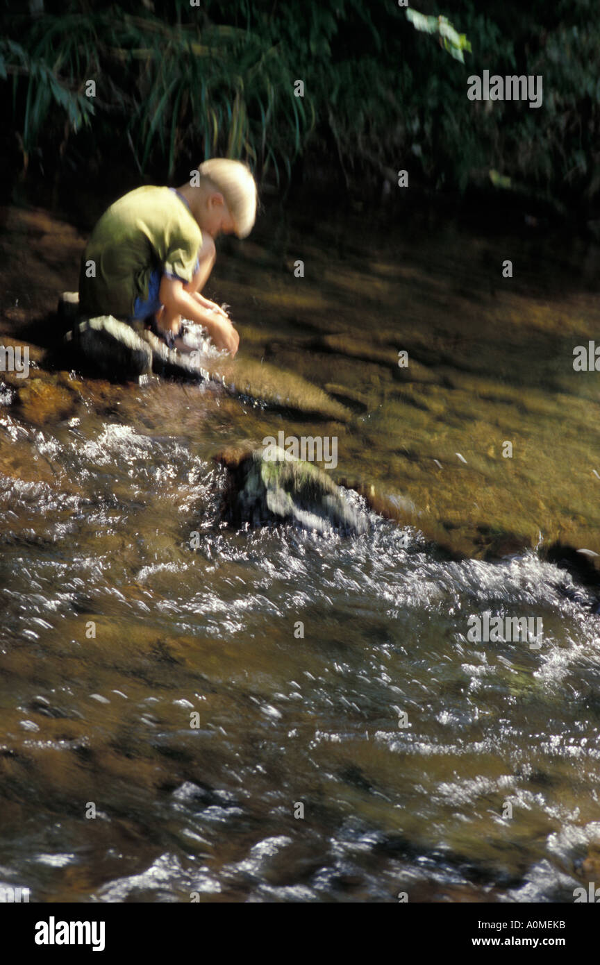 1 one young boy 5 6 7 8 years old playing in stream wet water fun ...