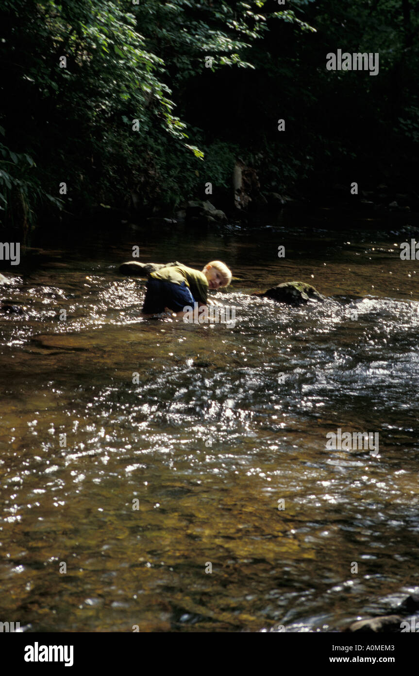 1 one young boy 5 6 7 8 years old playing in stream wet water fun ...