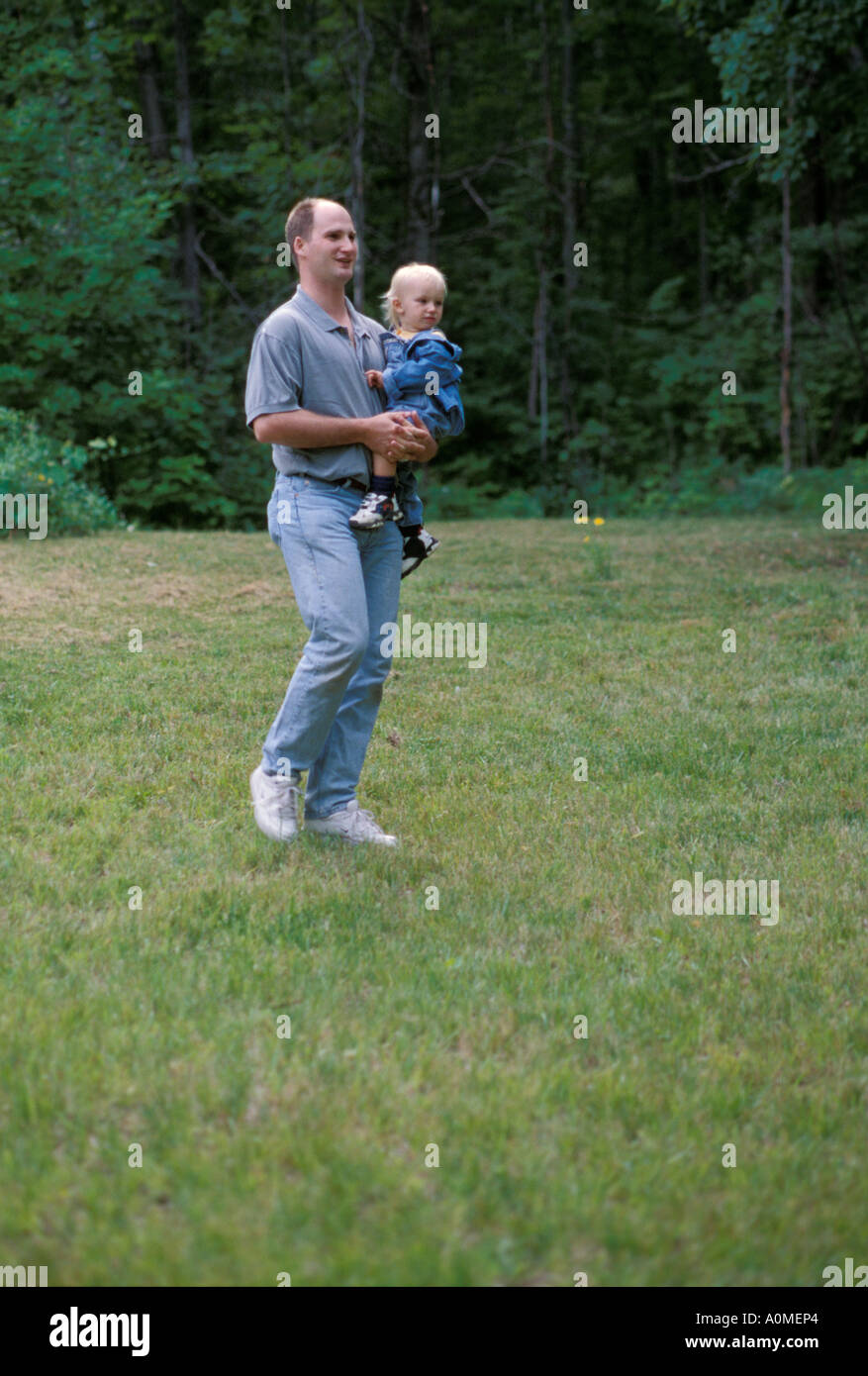 father carries son in arms 1 one young green grass happy frolic ...