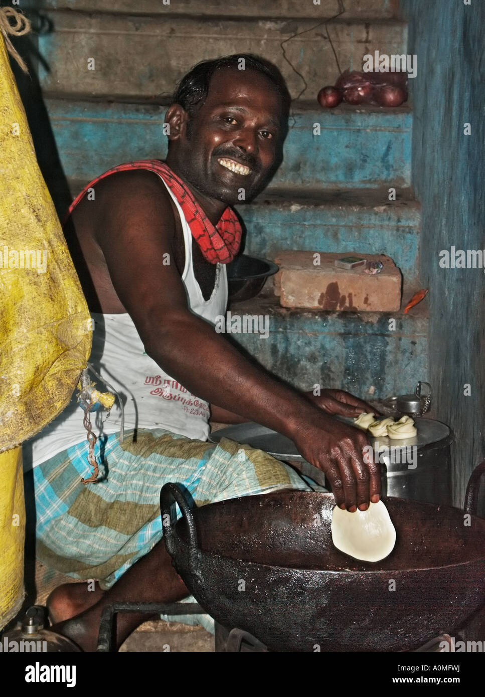 Indian man cooking deep fried Indian bread known as Wadai made from ...
