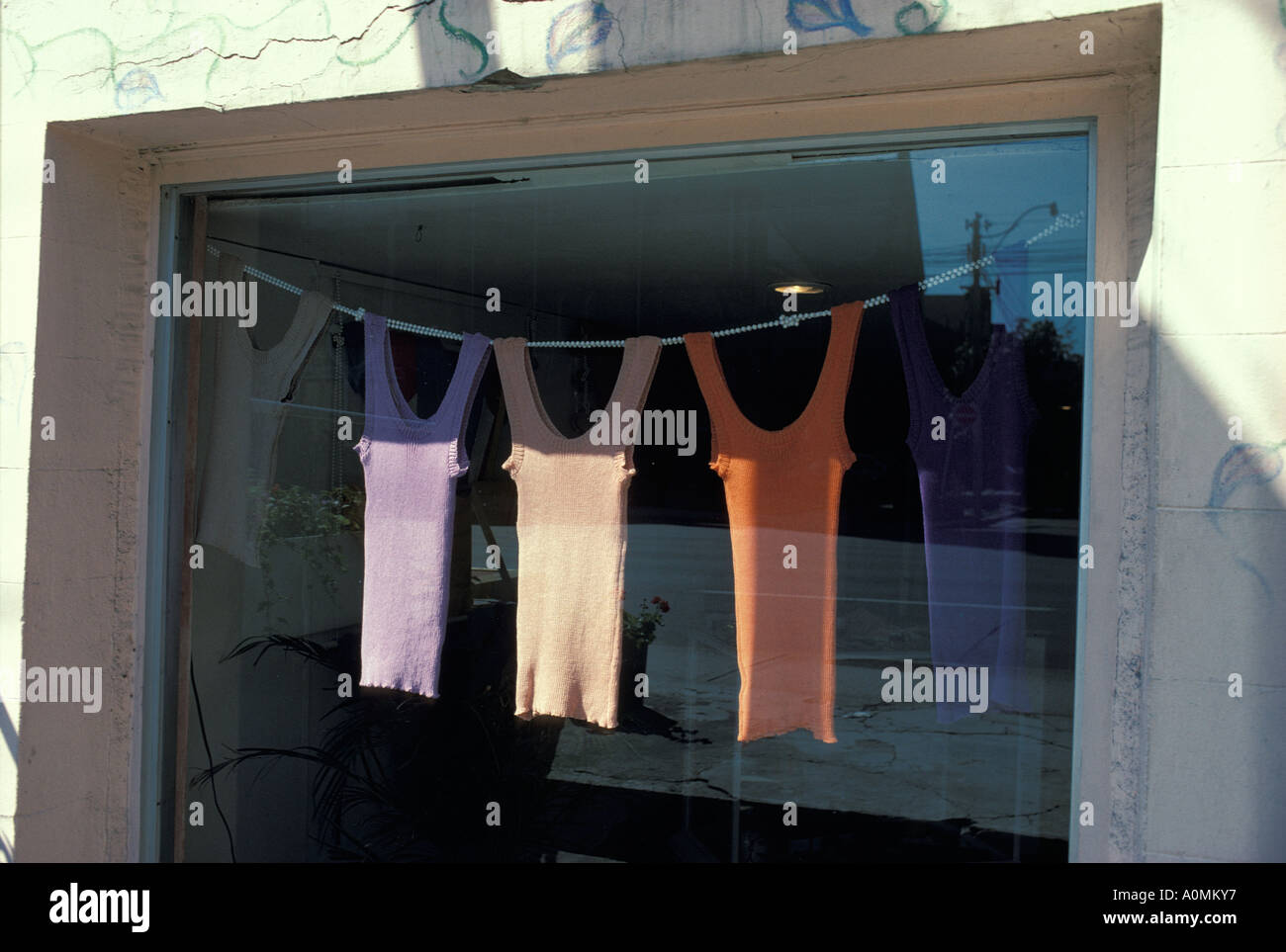 5 five colorful t shirts in store window Stock Photo - Alamy