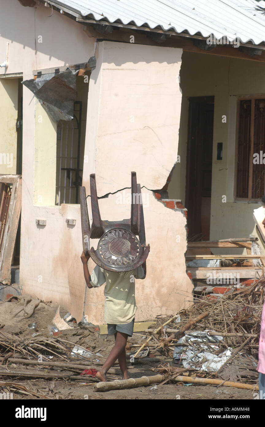 child running after stealing a chair from damaged house after Tsunami ...