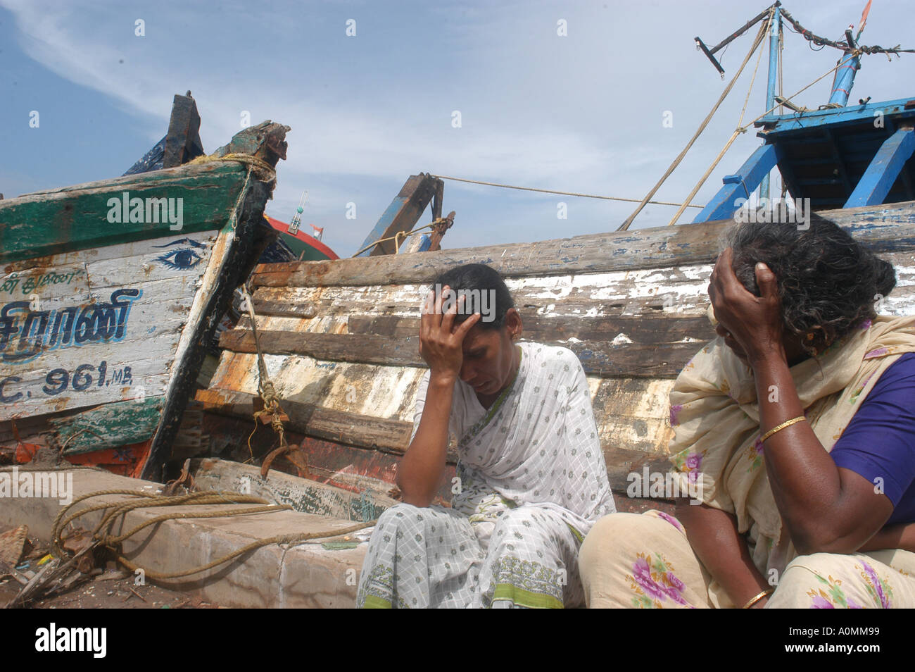 two women crying beating their heads in front of their boats after ...