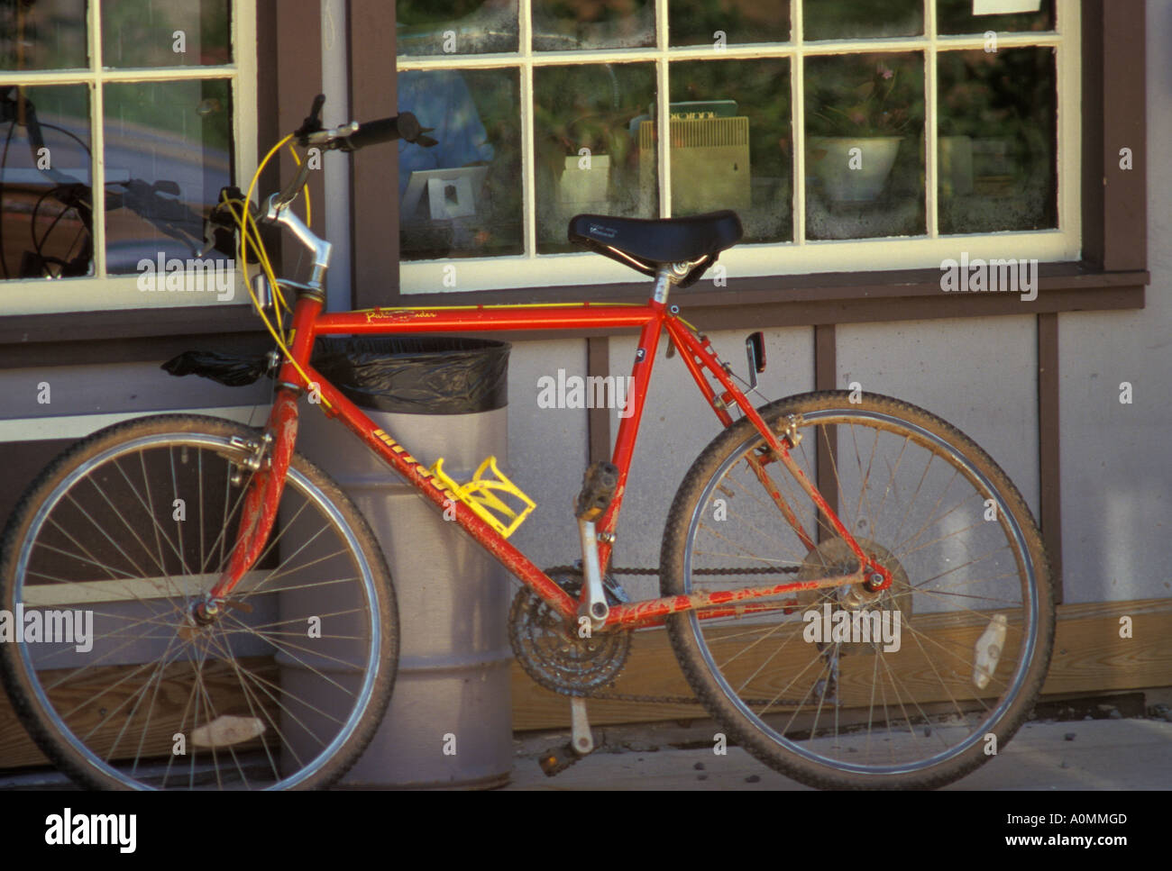 1 one lone bike bicycle rest store front red yellow Stock Photo - Alamy
