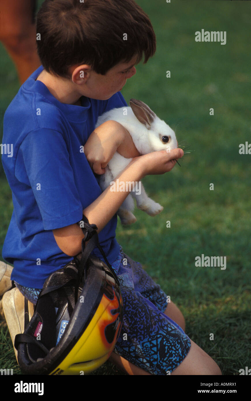young boy teen teenager holds white rabbit in arms vacation holiday ...