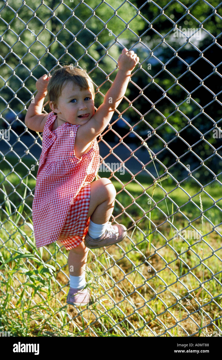 Toddler girl climbing chain link fence St Paul Minnesota Stock Photo ...