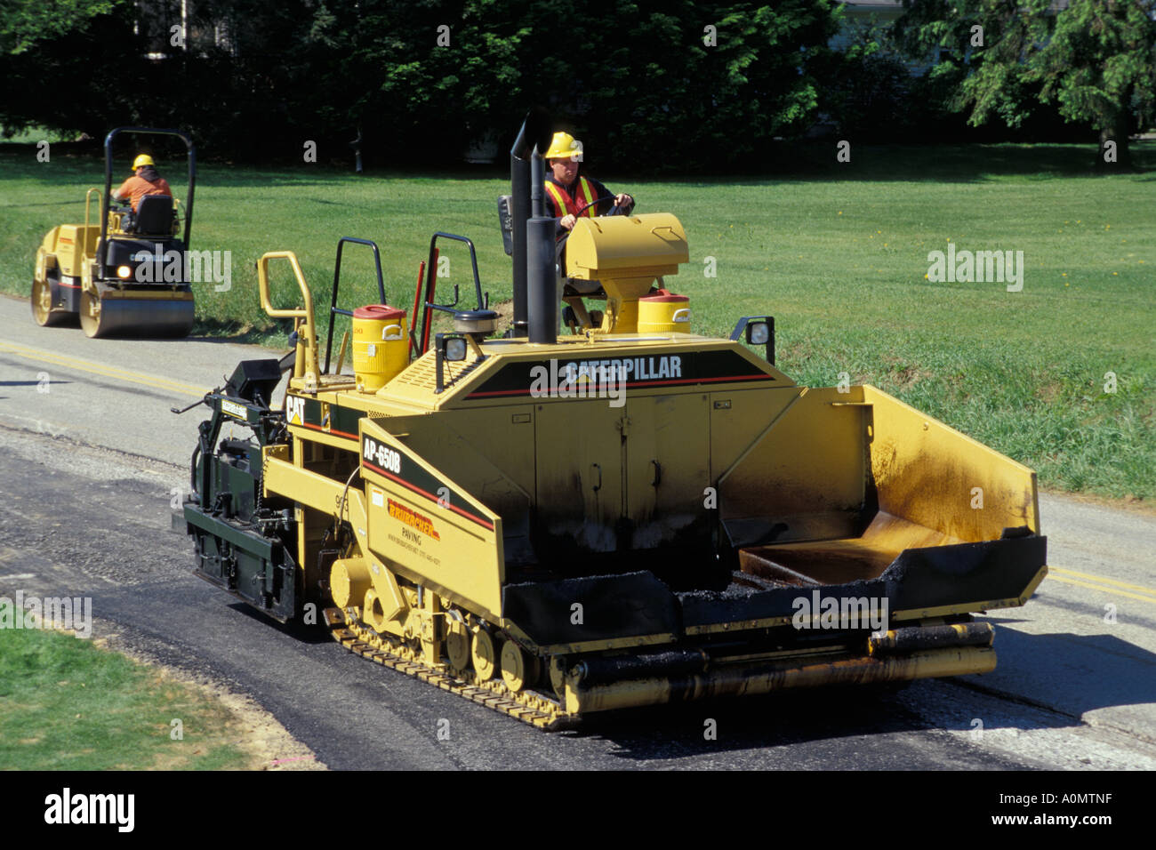 hi way highway road construction crew lays hot asphalt tar on street ...