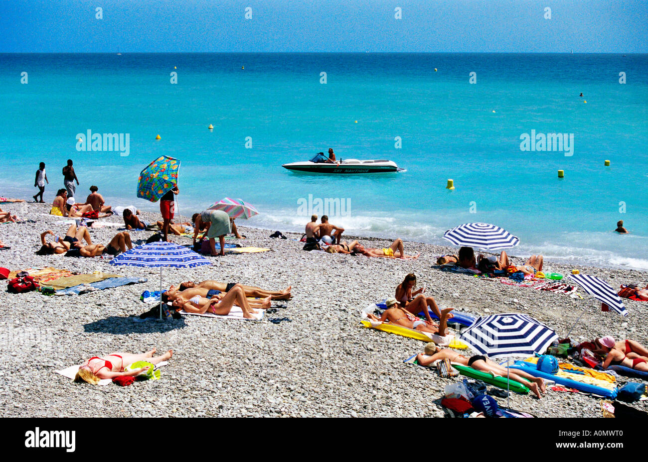 Beach life on the popular pebble beach by Promenade des Anglais in Nice ...