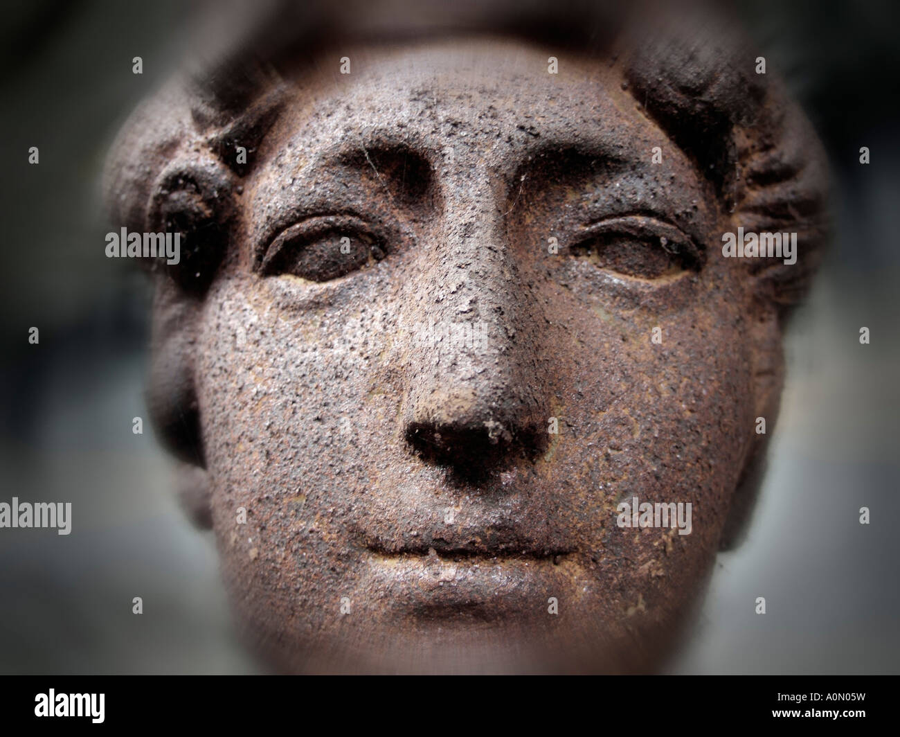 Rusty face on cast iron garden statue with blurred background Stock ...