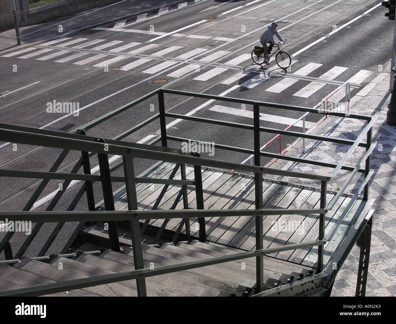 A cyclist cycling across a zebra crossing and tram lines, viewed from a ...