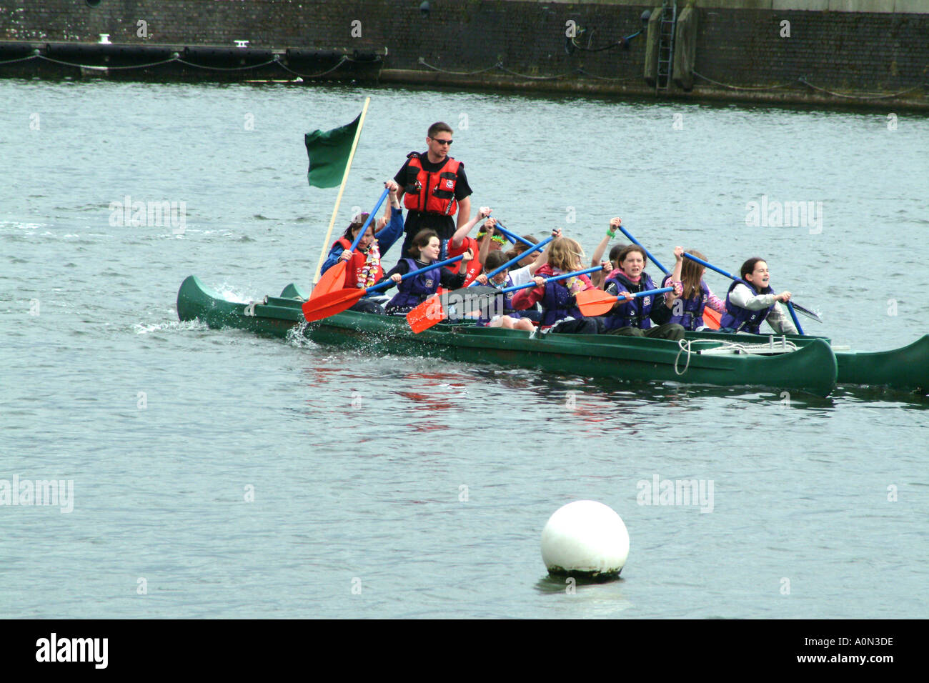 A team of children paddle a multi man canoe for an event at Salford ...
