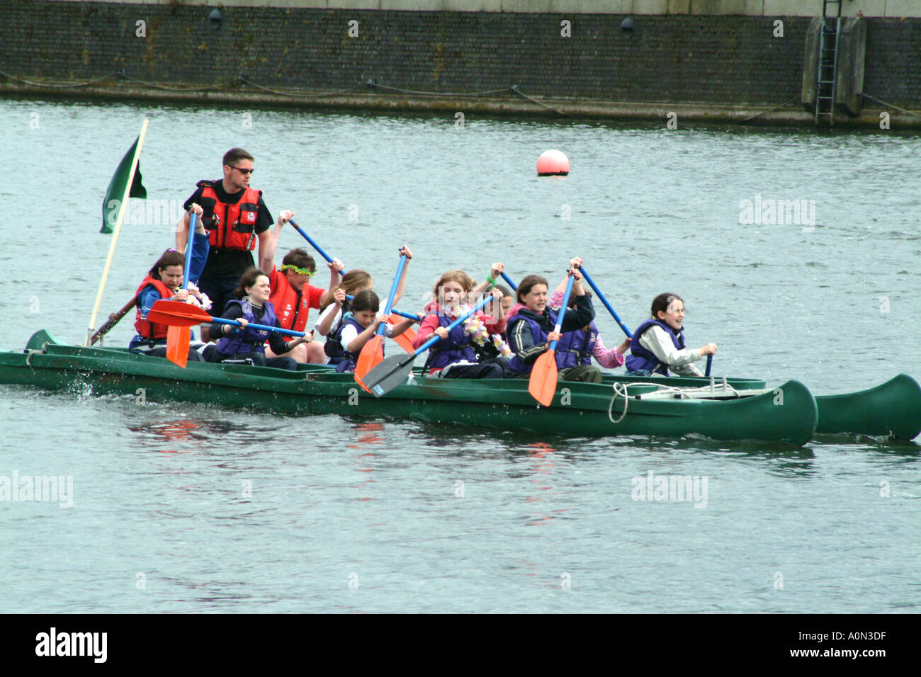 A team of children paddle a multi man canoe for an event at Salford ...