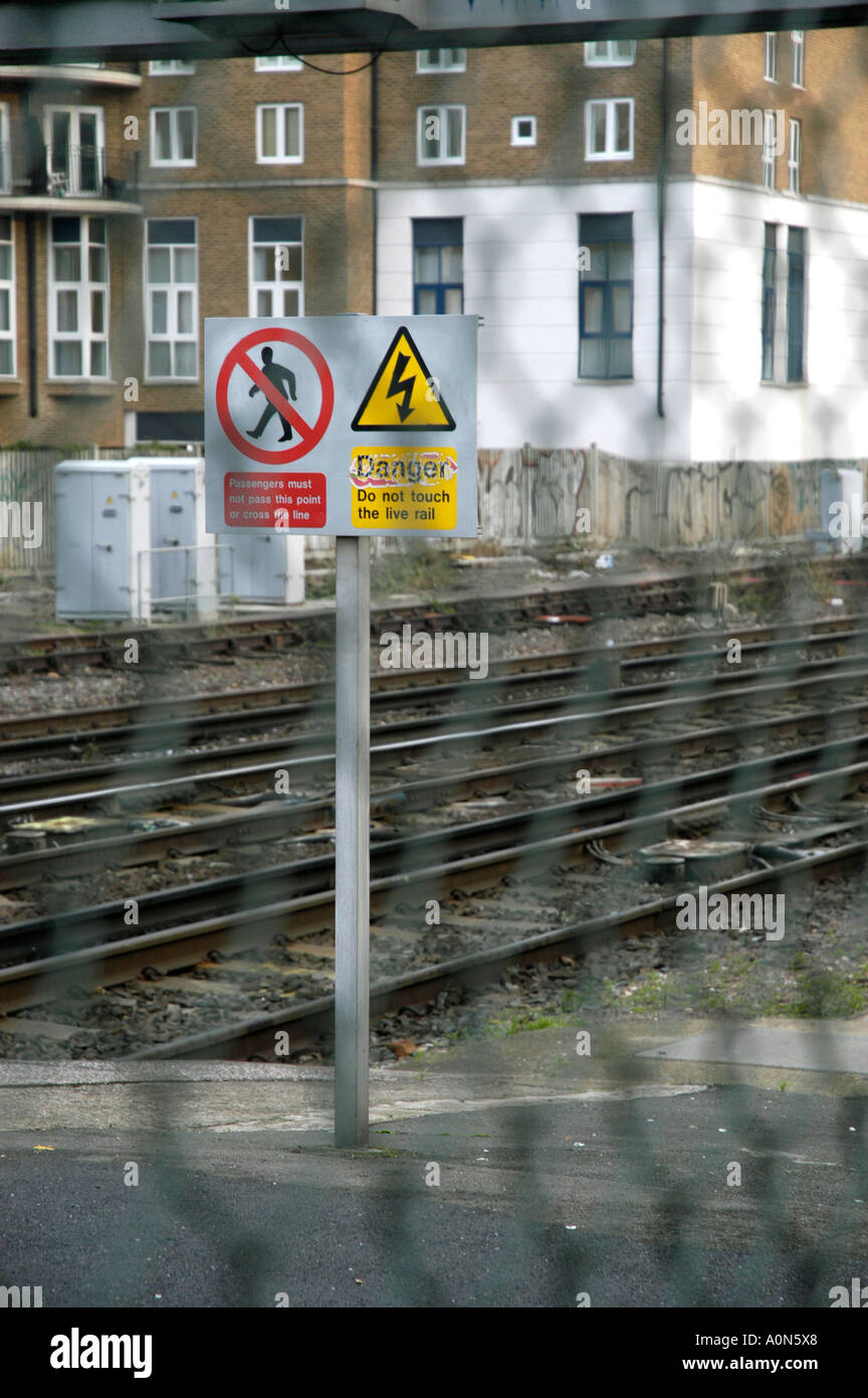 Looking through chain link fence at danger signs on railway lines Stock ...