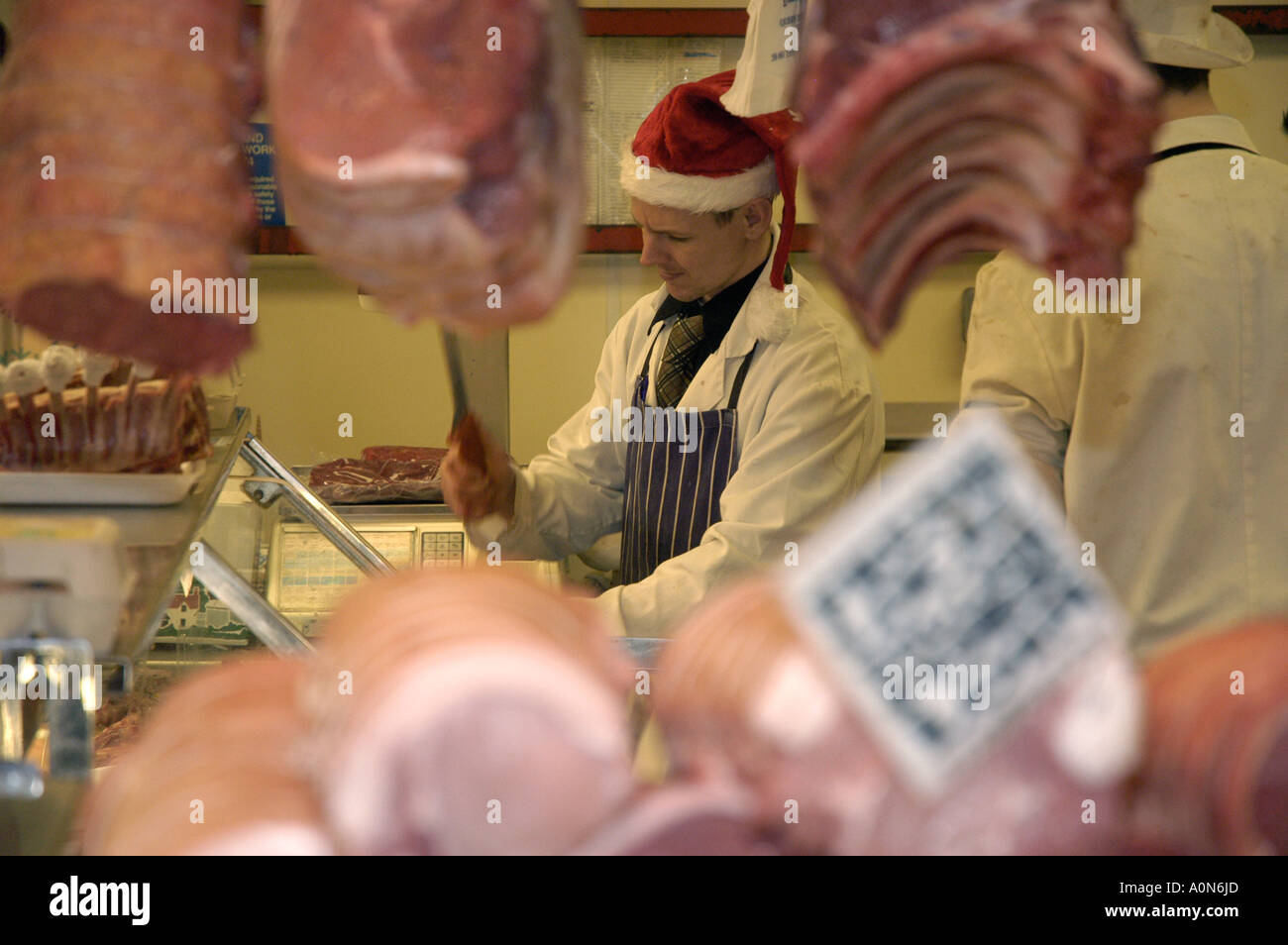 Christmas butcher busy at work at a butchers in Oxfords covered market ...