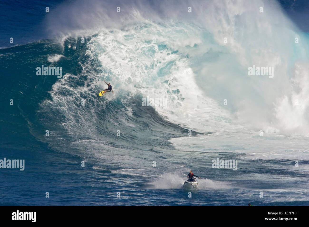 A tow in surfer and jetski at Peahi (Jaws) off Maui, Hawaii Stock Photo ...