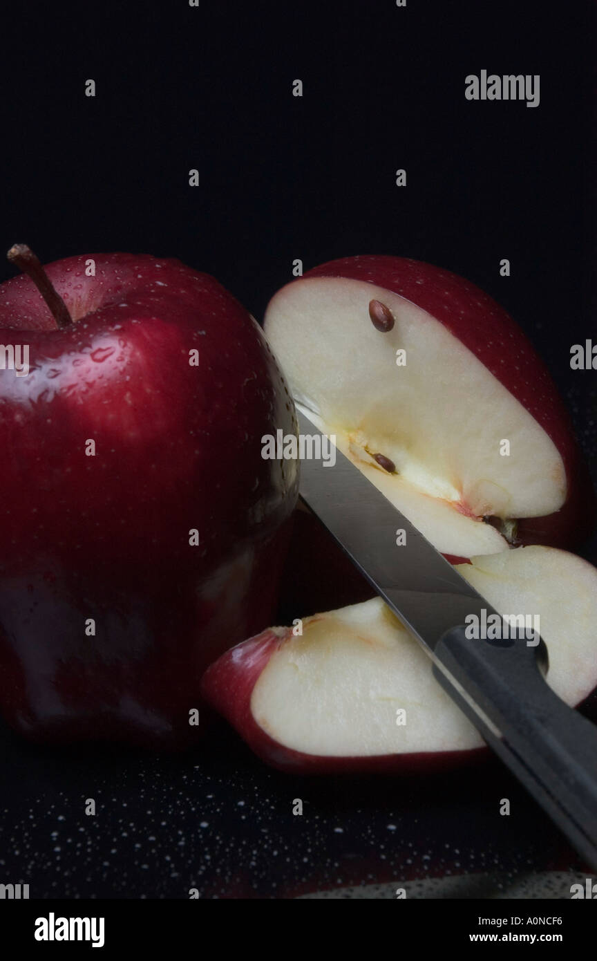 Sliced red apple with knife on black background Stock Photo - Alamy
