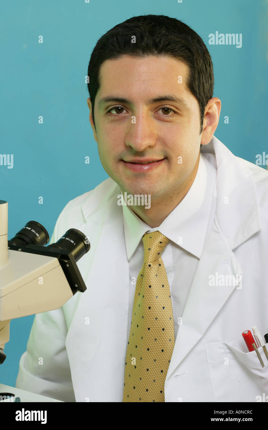 Hispanic researcher, medical technician or doctor uses his microscope ...