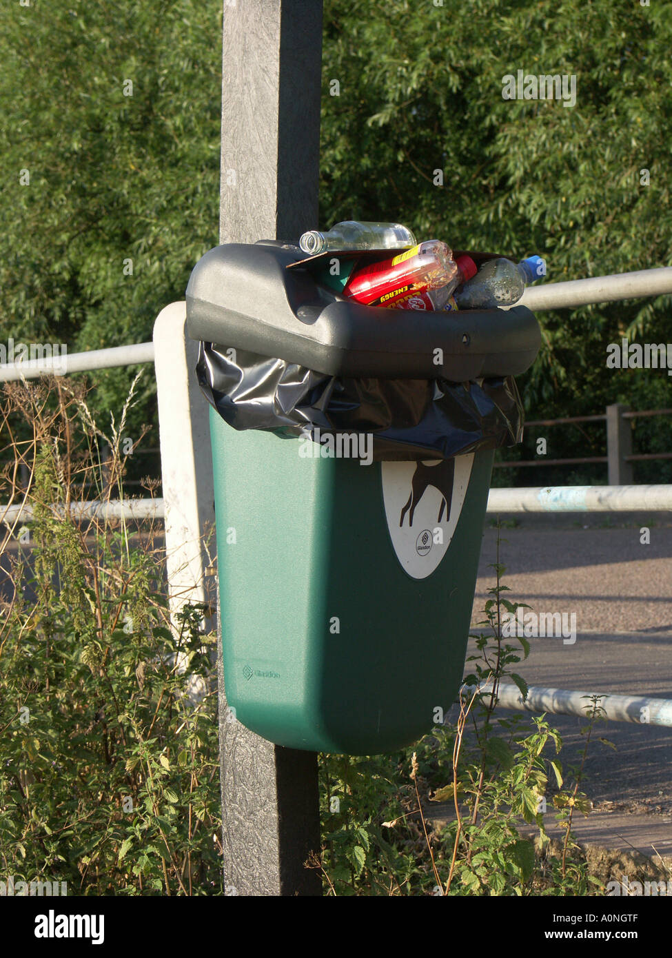 Full litter bin attached to a post Stock Photo - Alamy
