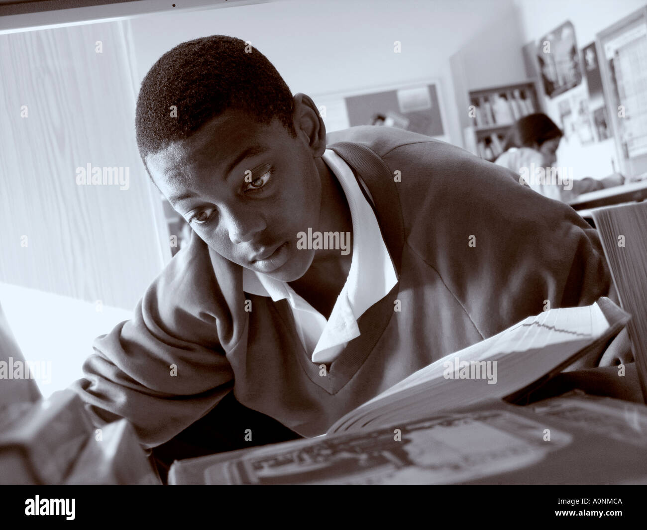Teenage black boy student studying in school library Stock Photo - Alamy