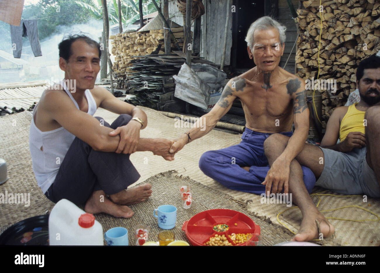 Dayak men relaxing on the Rajang river Sarawak Malaysia Stock Photo - Alamy
