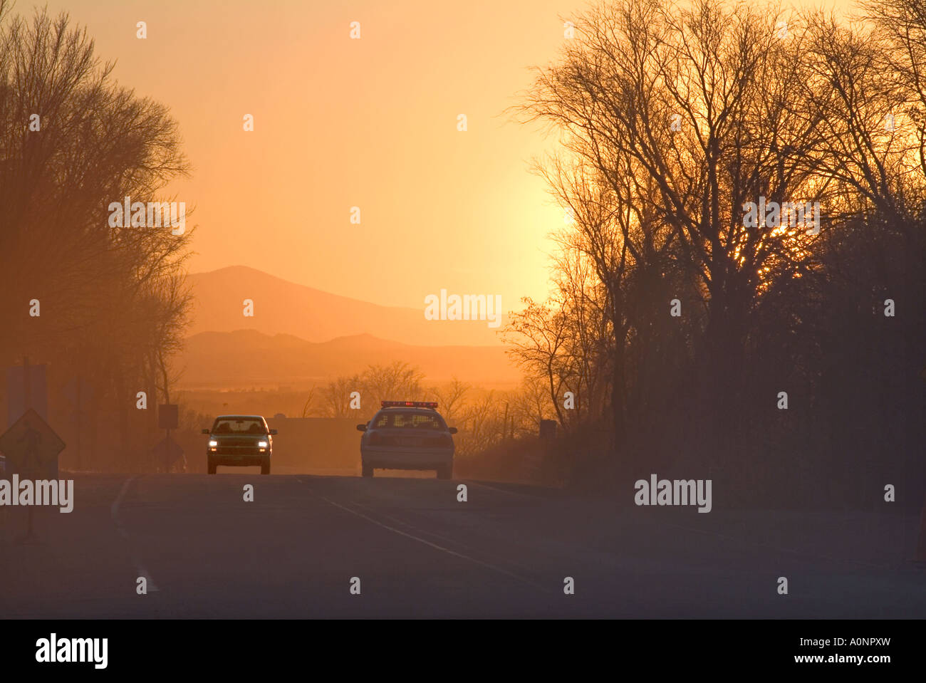 Dusk view of car traveling down roadway at sunset of road Stock Photo ...