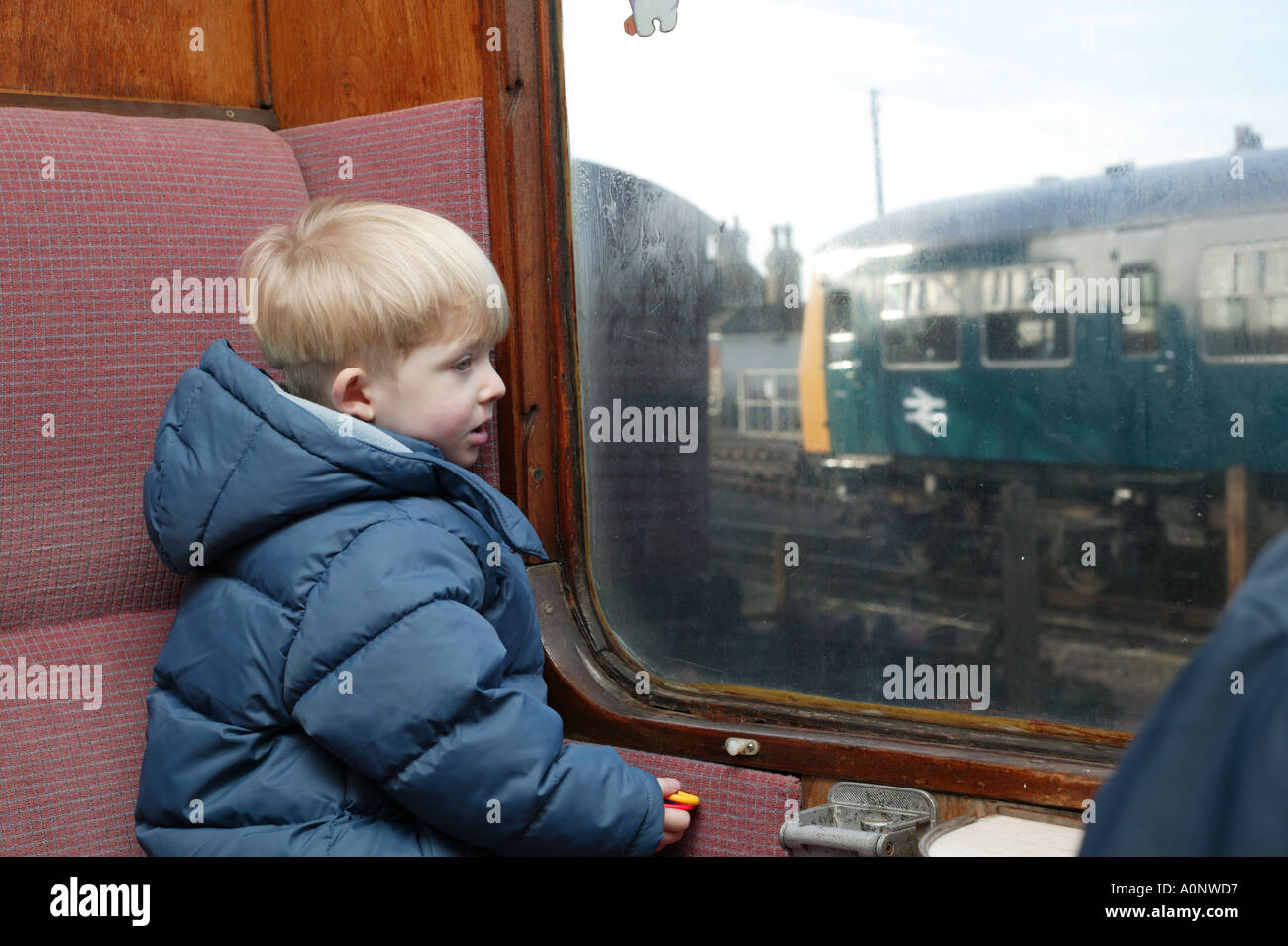 Young boy watching a train pass by Stock Photo - Alamy