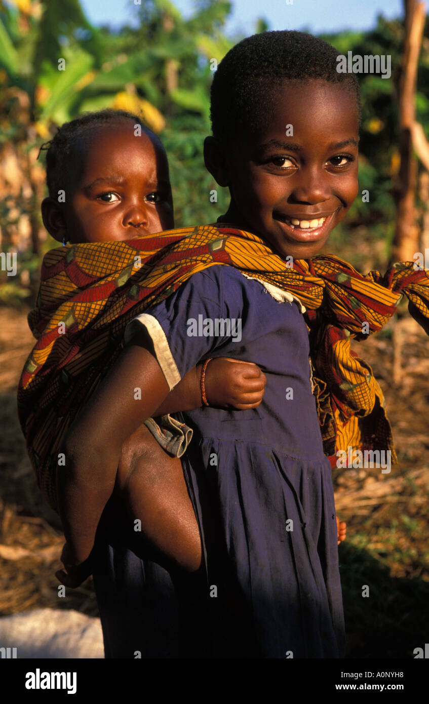 A girl carrying her baby brother on her back Stock Photo - Alamy