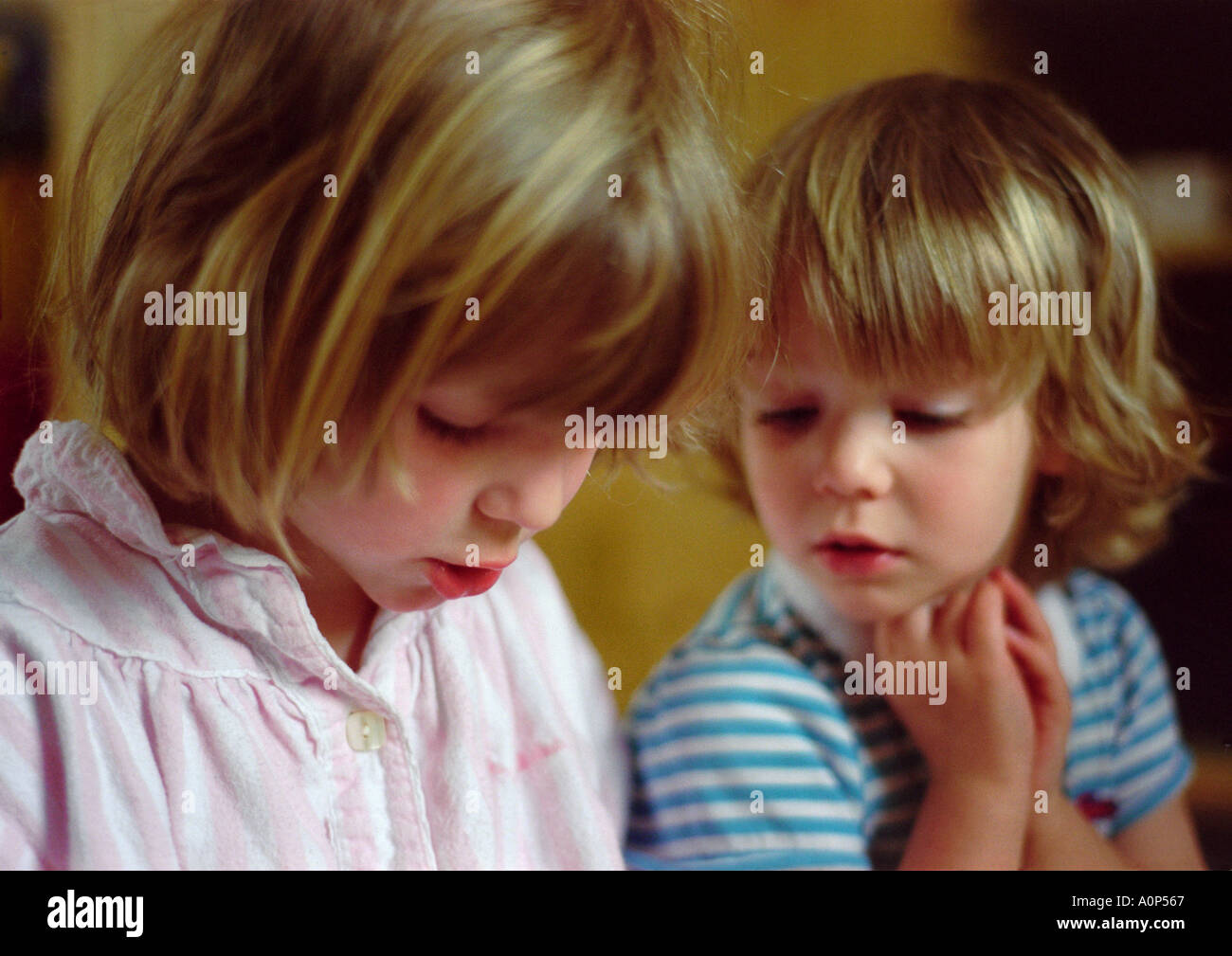 two young girls or sisters, talking together and engrossed in their own ...