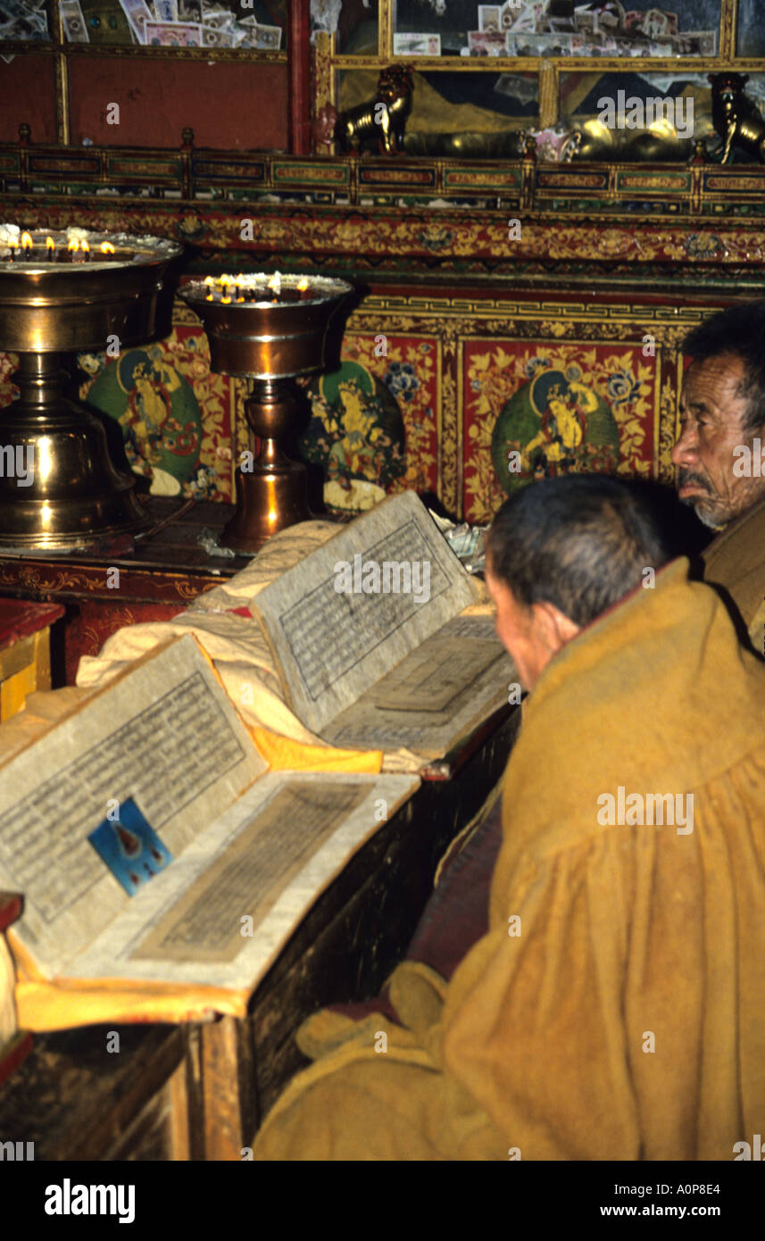 Interior of a Tibetan monastery with monks studying their holy books ...