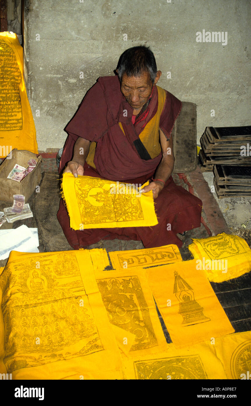A Tibetan monk working on holy papers and scrolls in a monastery in ...