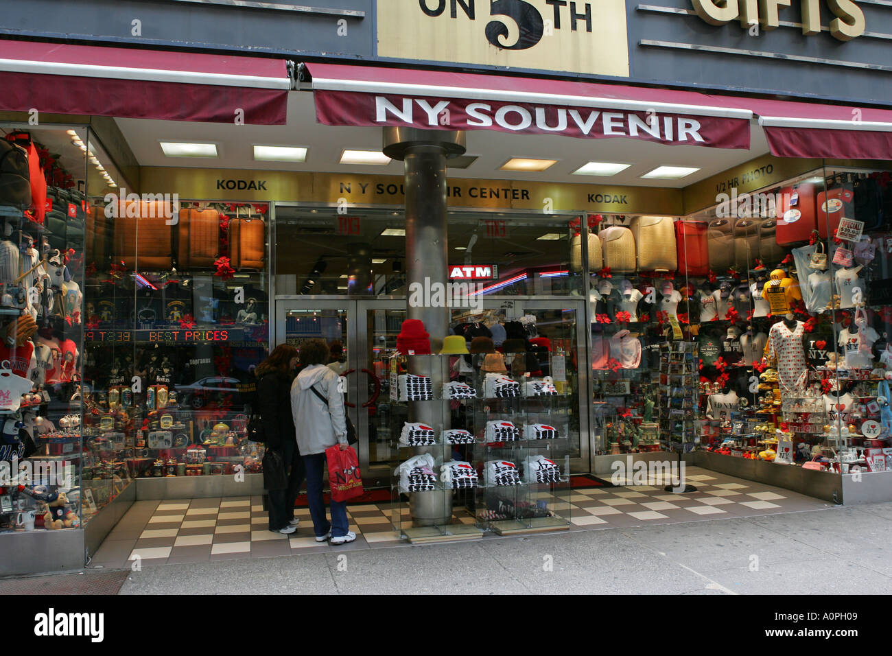 Tourists browse the cheap low cost goods in a 5th fifth Avenue souvenir ...