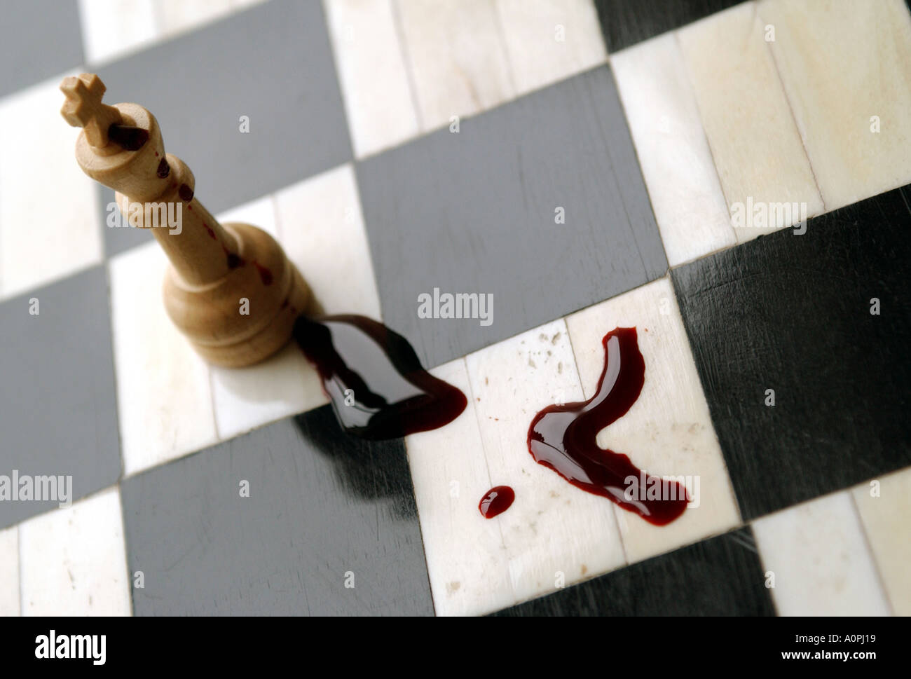 a king chess piece on a chess board with blood on it Stock Photo - Alamy