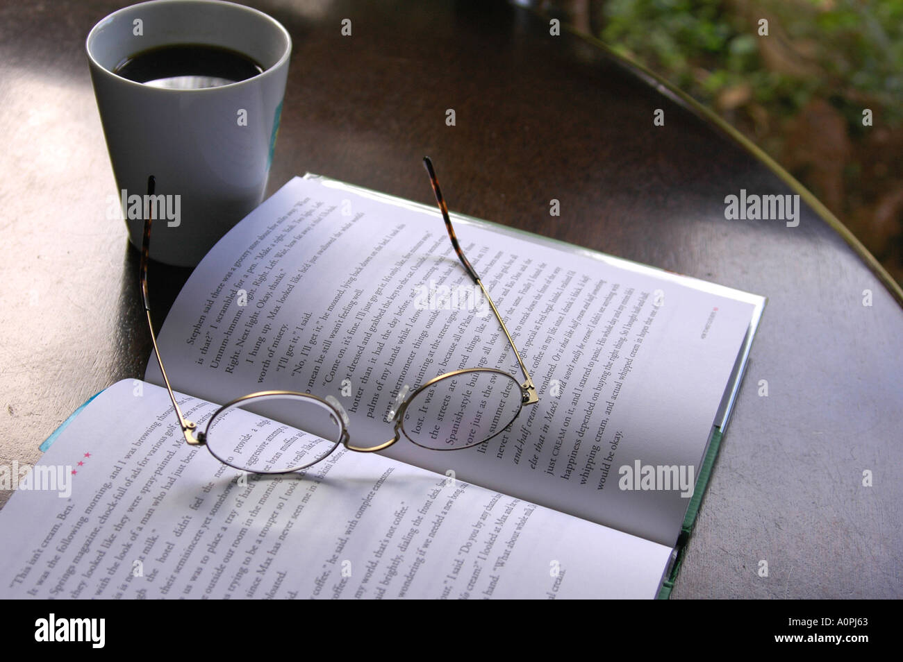 Reading glasses placed on a book with a cup of coffee Stock Photo - Alamy