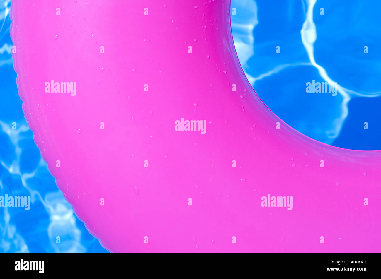 Pink float toy against bright blue pool Stock Photo - Alamy