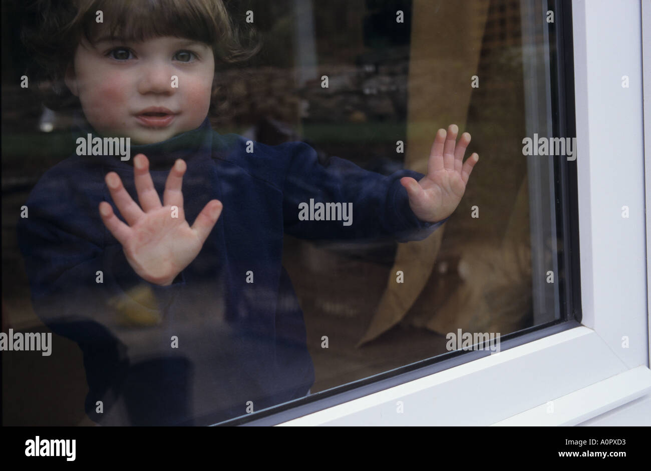 Young girl looking through window Stock Photo - Alamy