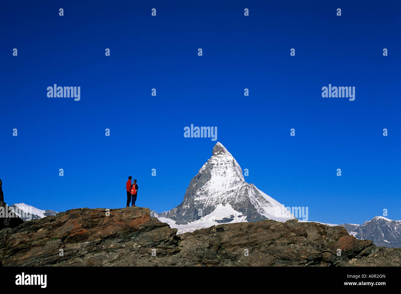 Hikers on rocks and the Matterhorn Rotenboden Zermatt Valais Swiss Alps ...