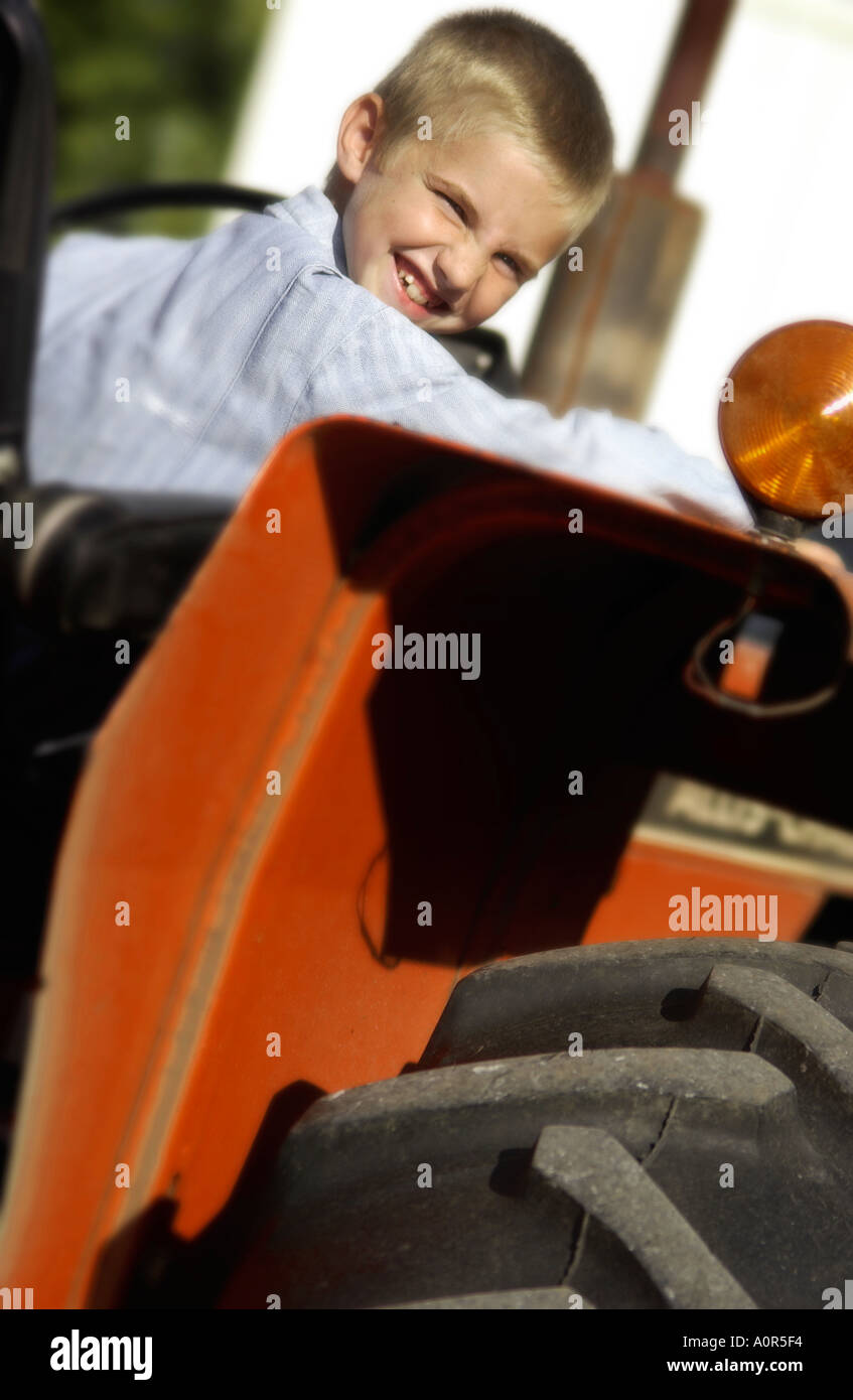 Boy sitting on tractor Stock Photo - Alamy