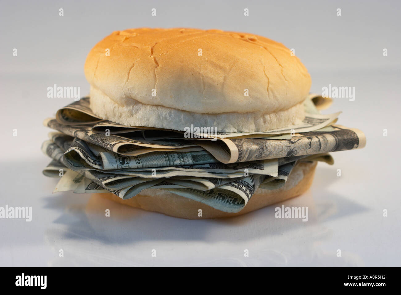 A money sandwich of United States dollars on a hamburger bun Stock ...