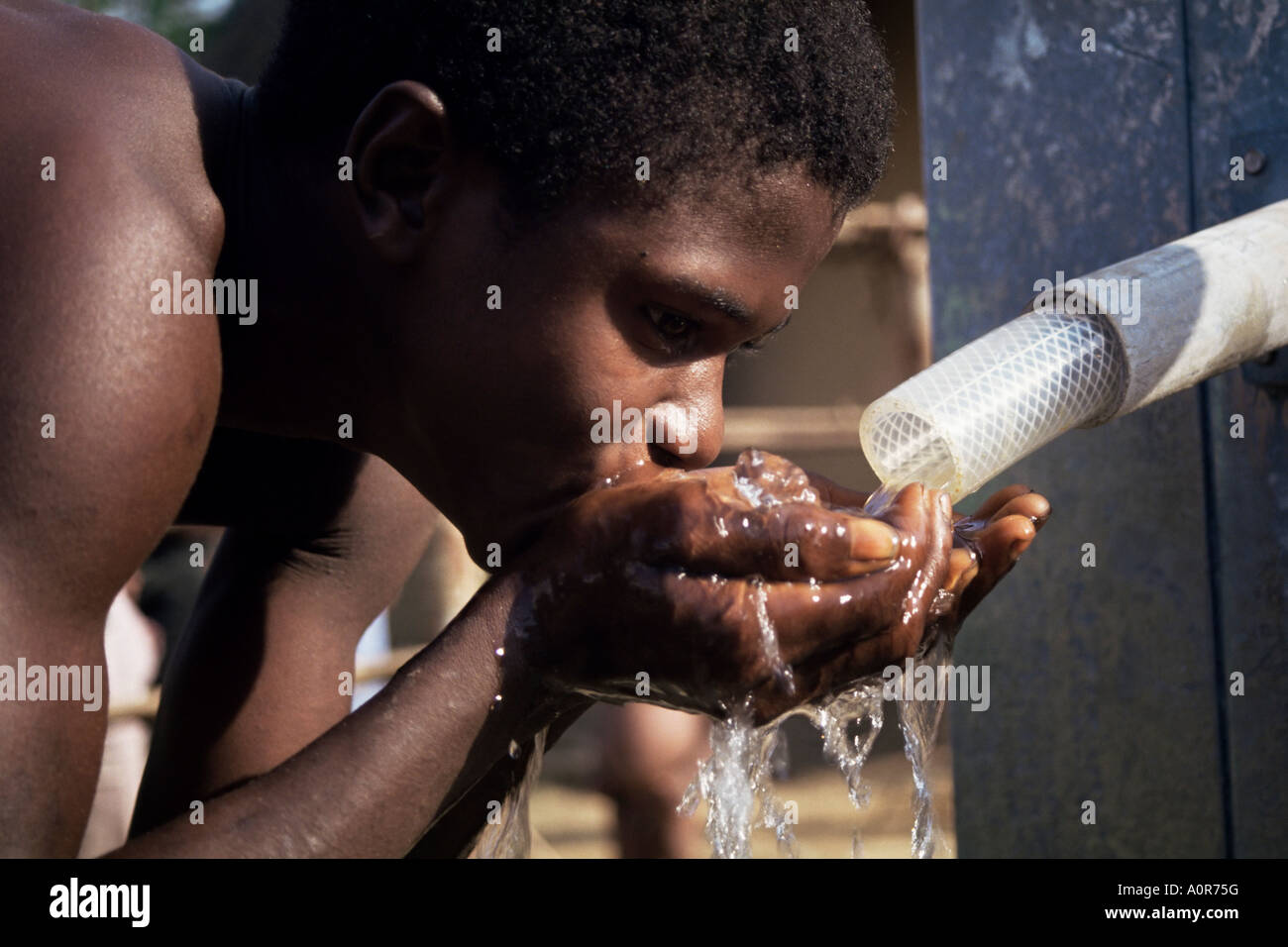 Teenage boy drinking from new UNICEF well Vahun Liberia West Africa ...