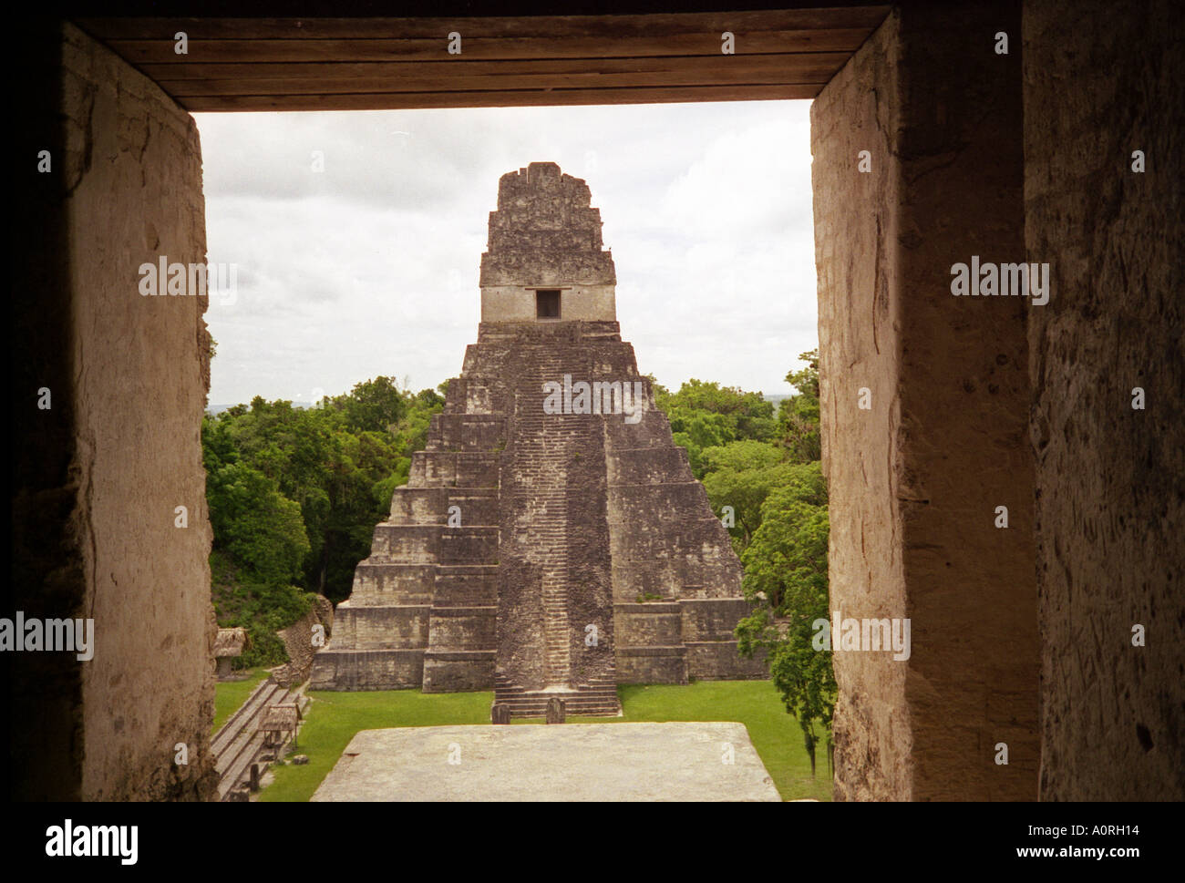 Panoramic view imposing Maya stone pyramid through entry door at top ...