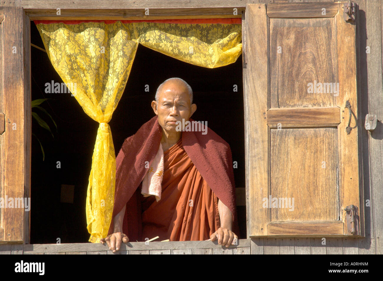 Local monk of the Pah oh minority standing at window of monastery ...