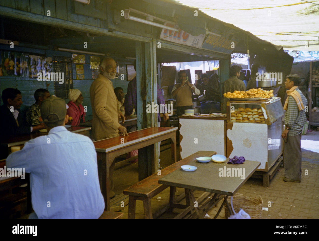 Group men in animated traditional open air cafe kiosk in busy city ...