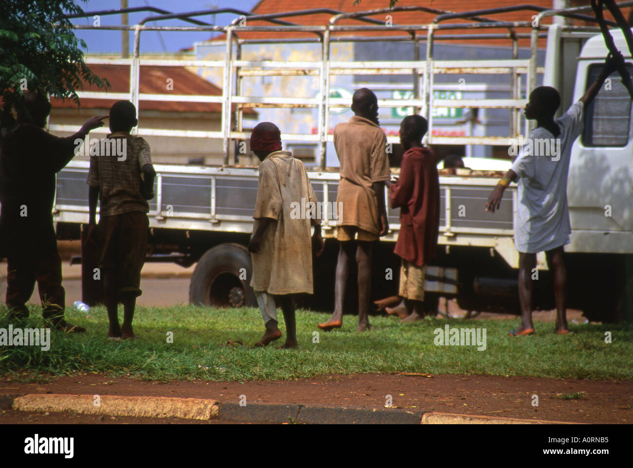 Group of orphan street children poorly dressed play soccer acrobatic ...