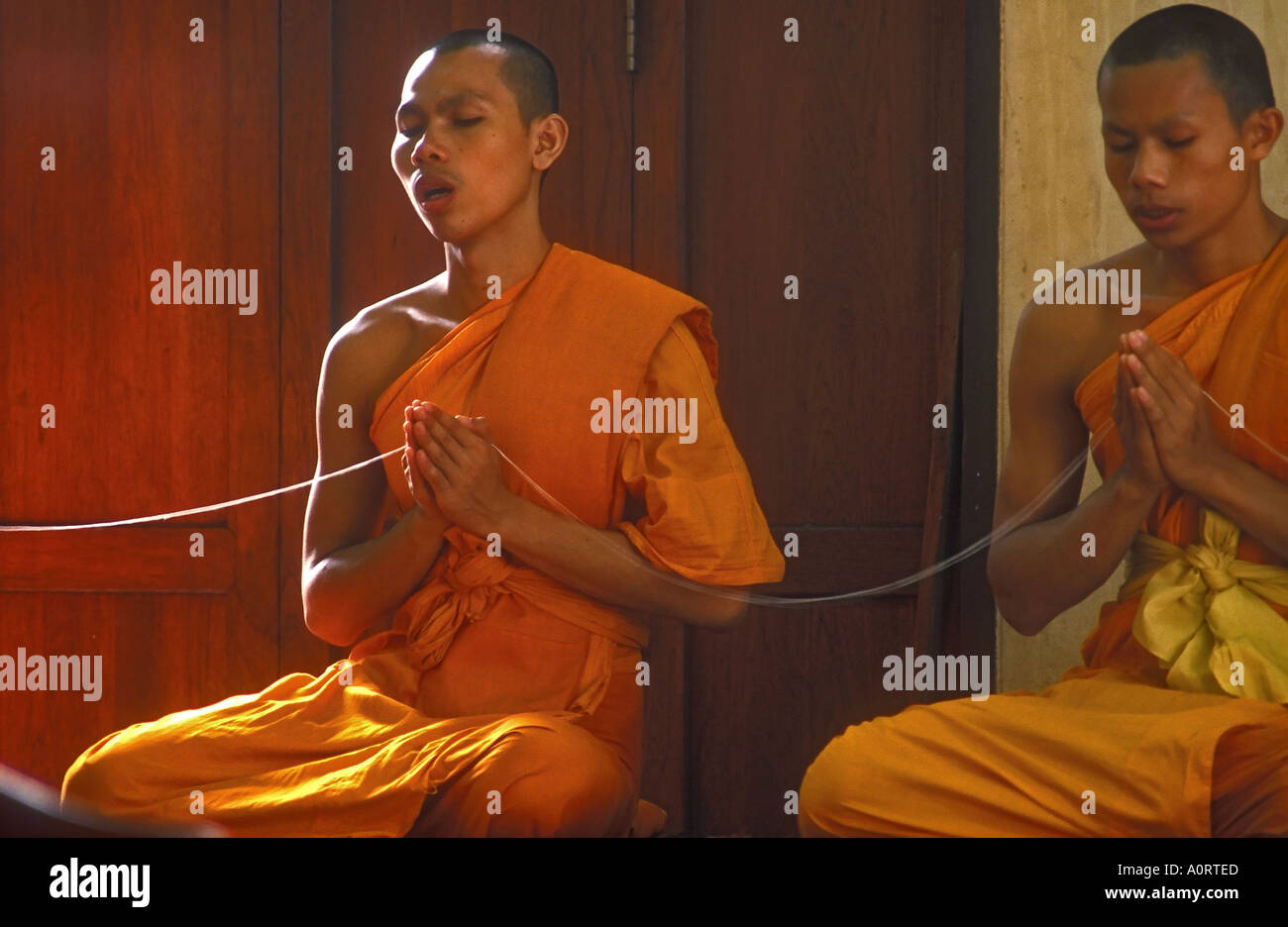 Monk engaged in a circle of prayer joined by a piece of string at a ...