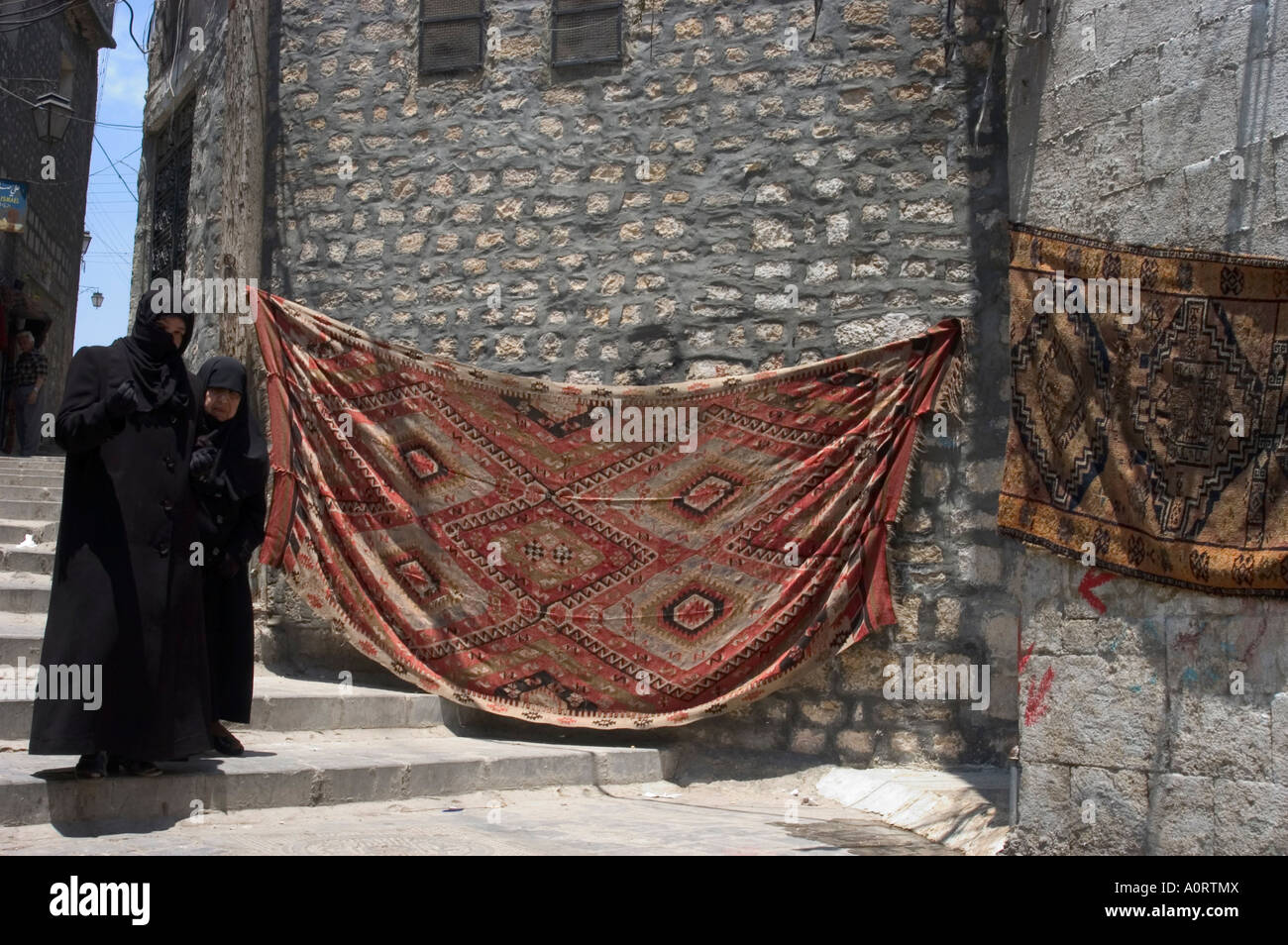 Local woman walking down steps blanket on wall Aleppo Haleb Syria ...