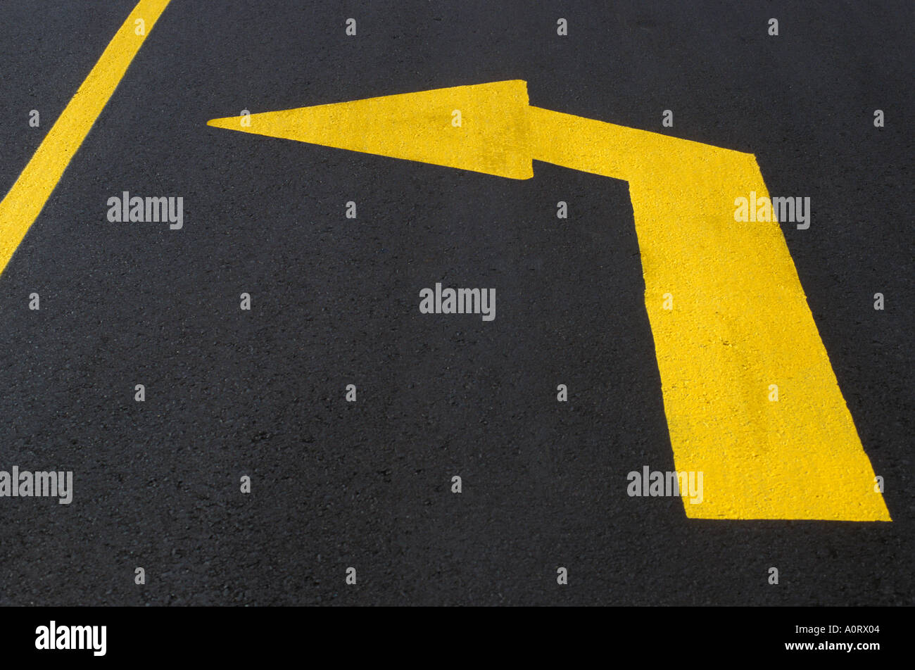 A large yellow directional arrow painted directly onto the road surface ...