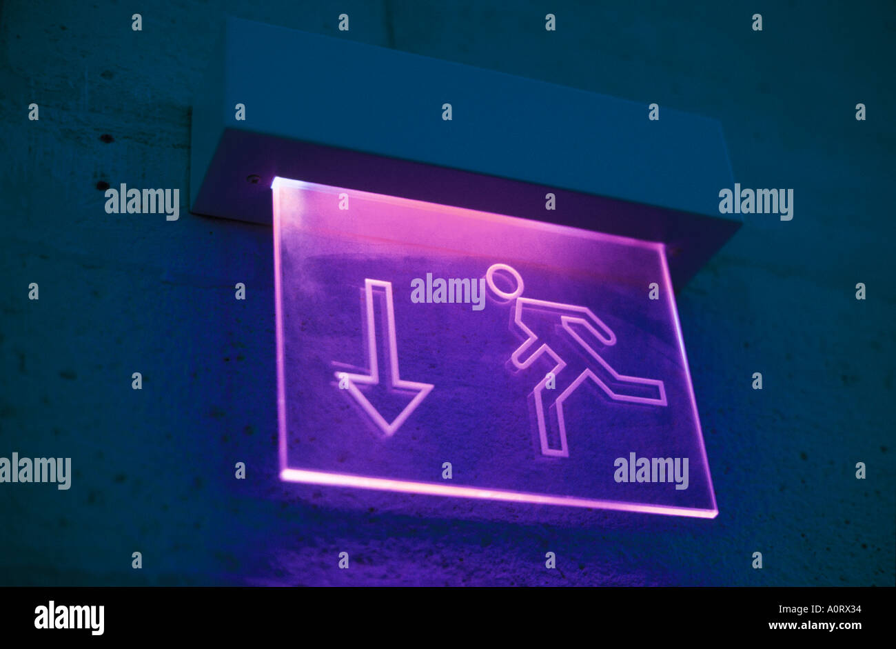 Glowing purple sign with a person running or walking and an arrow ...